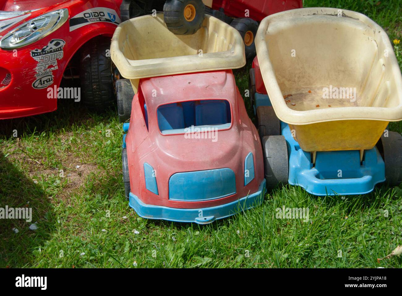A pile of colorful plastic toy trucks, symbolizing abandoned childhood ...