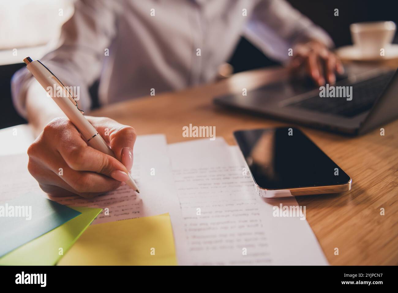 Professional businesswoman in smart casual attire taking notes on paper ...