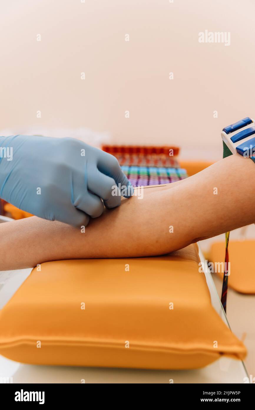Healthcare professional preparing for a blood draw in a clinical ...