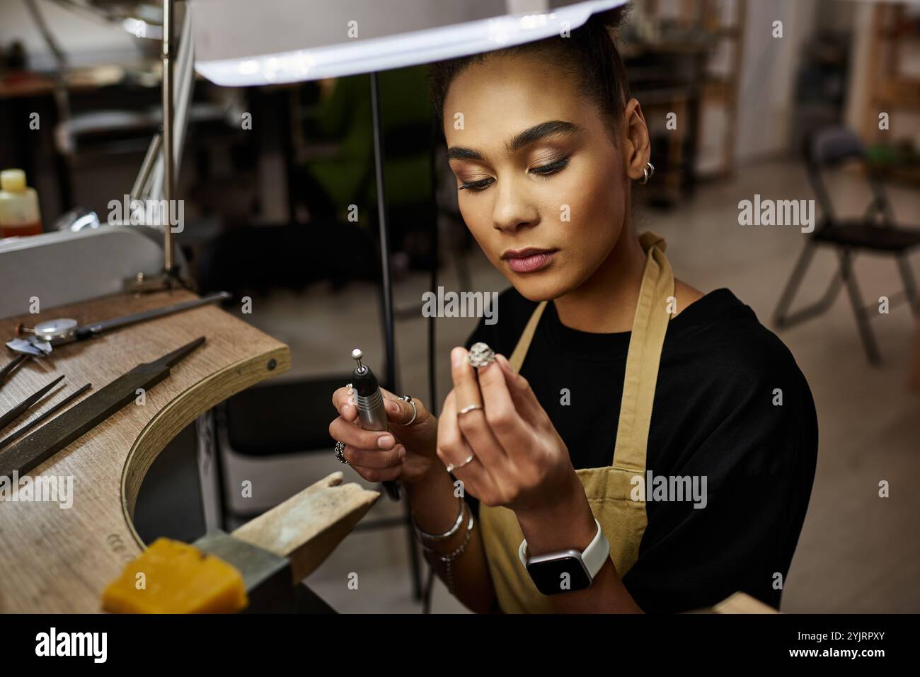 A talented jeweler focuses intently on creating a stunning piece with precision tools Stock ...