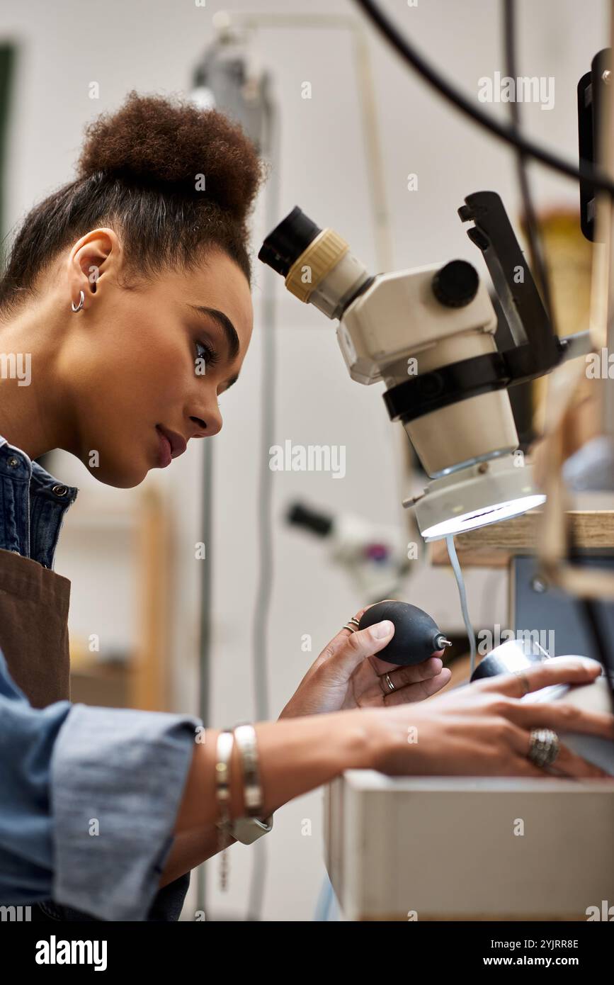 A talented woman examines a unique piece while working diligently in ...