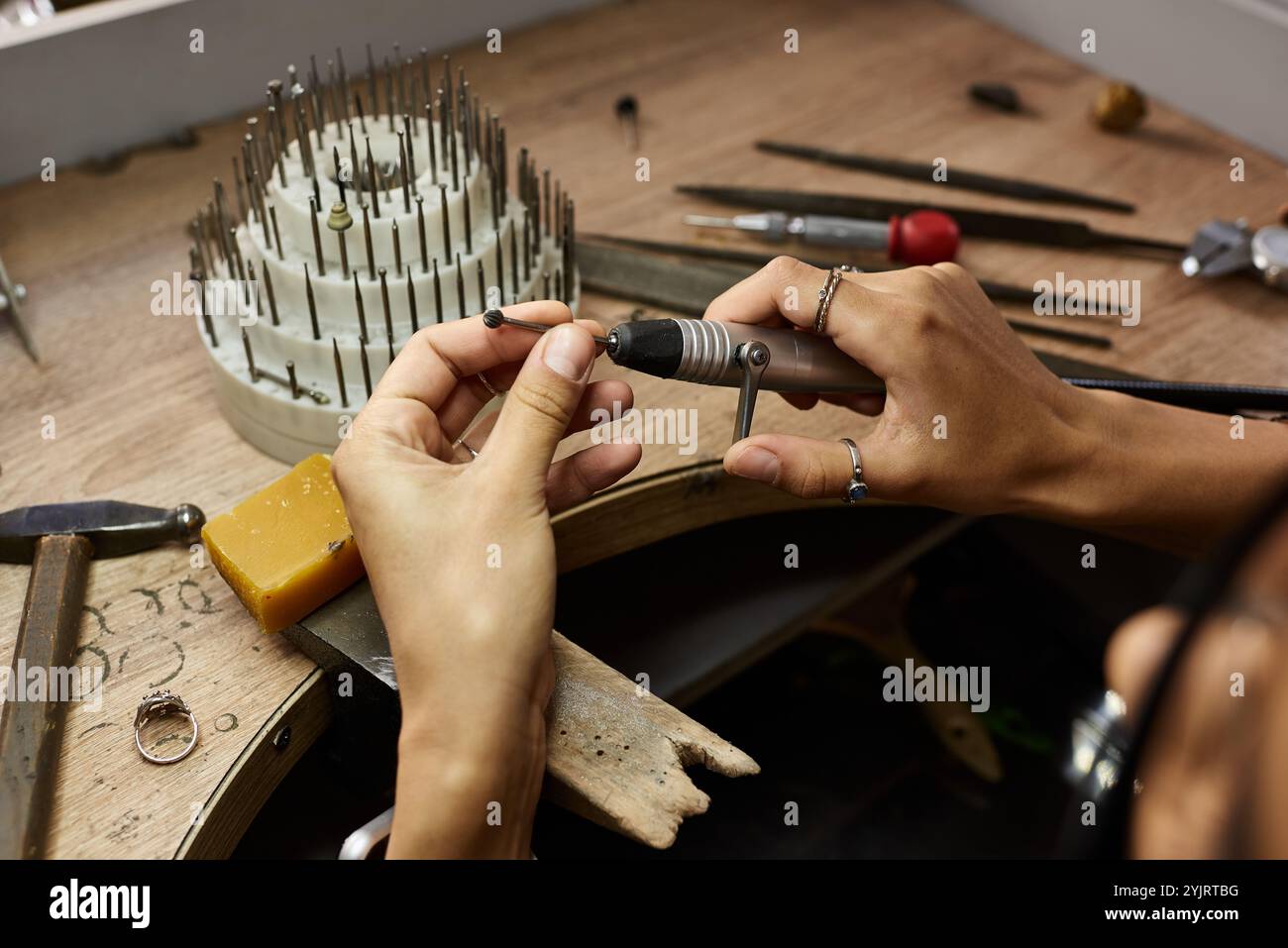 An artisan focuses on crafting a beautiful piece of jewelry with ...