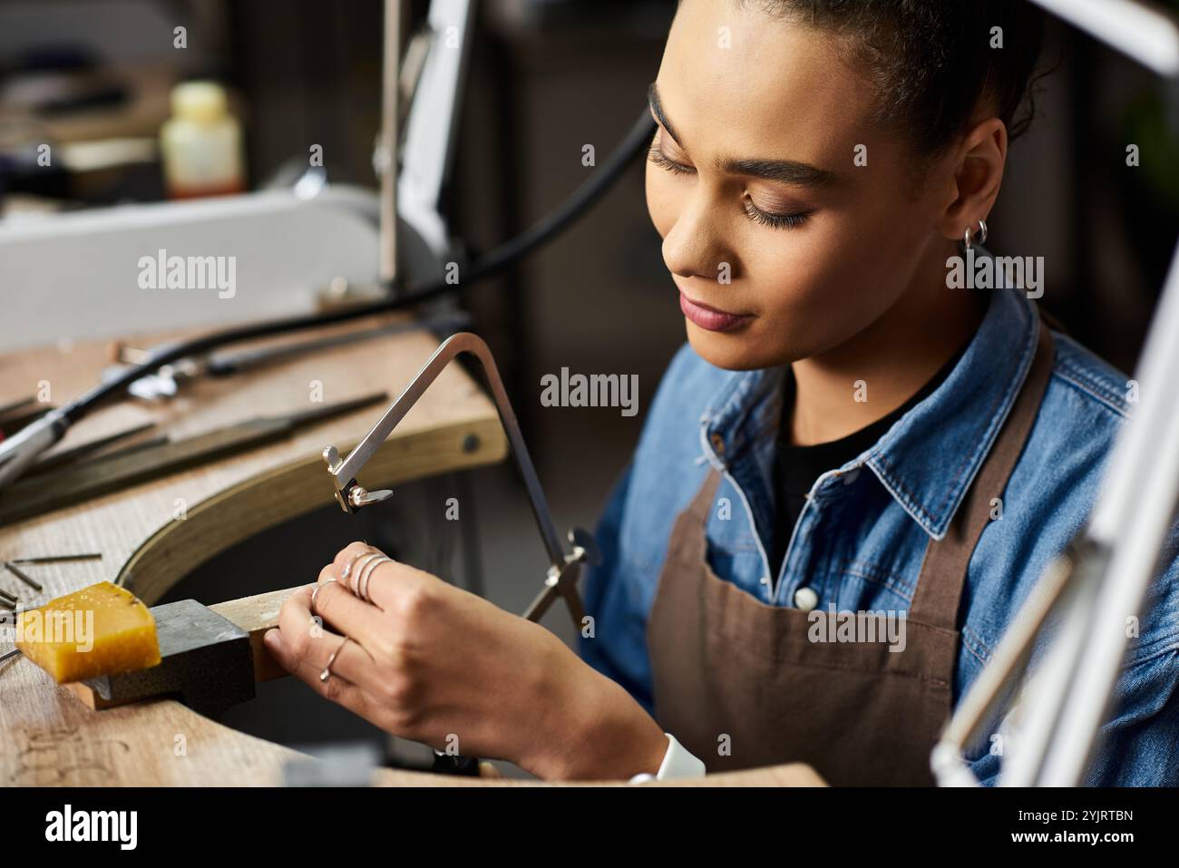 An artisan focused on jewelry design, working attentively in her ...