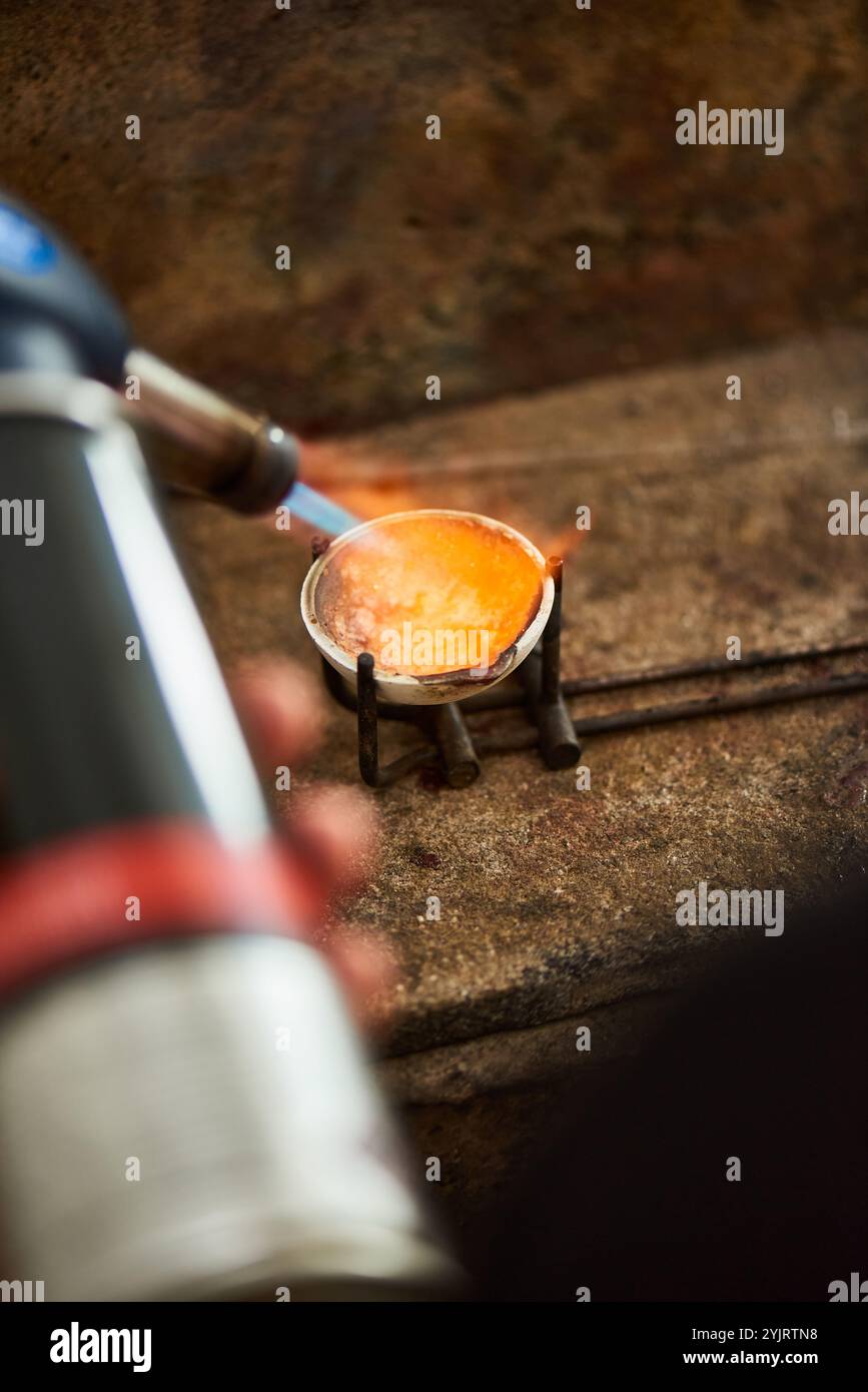 Hot flame dances above molten metal as a talented artisan shapes ...
