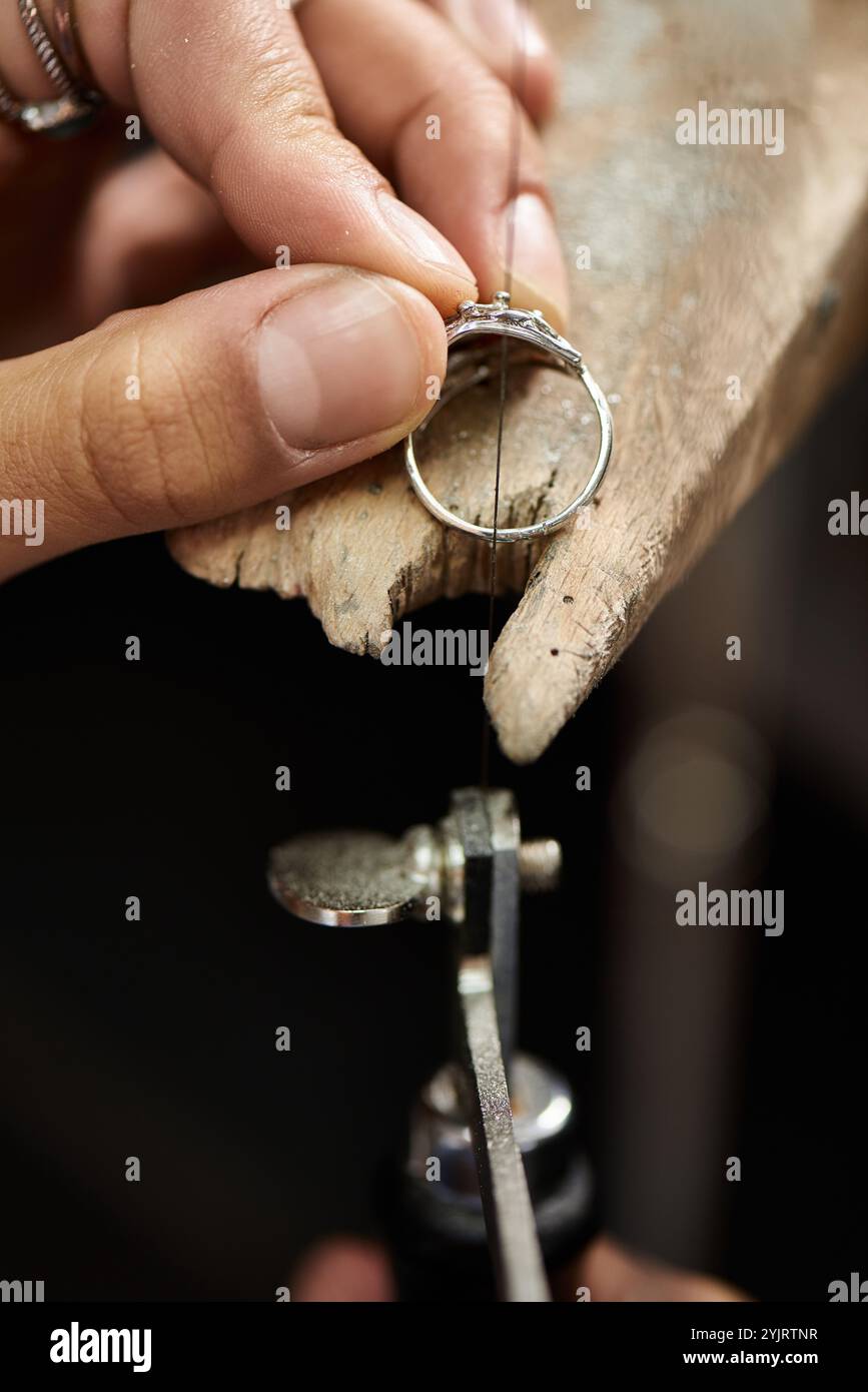 Craftsmanship shines as hands work meticulously on a sparkling ring set ...