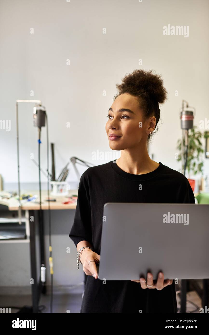 The beautiful woman holds a laptop while contemplating her artistic ...