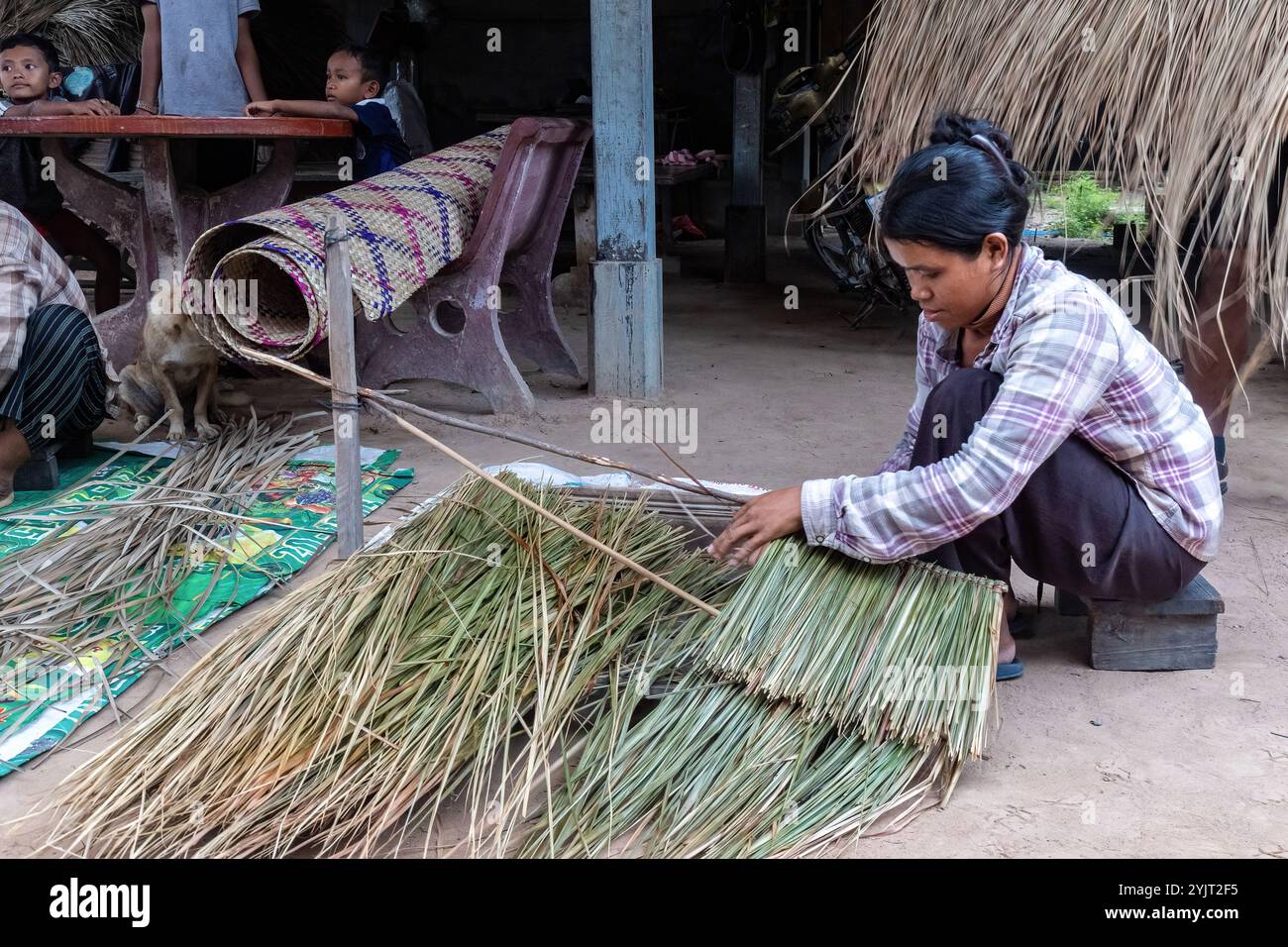 People demonstrating the manufacre of brooms and roofing covers. Aslo ...