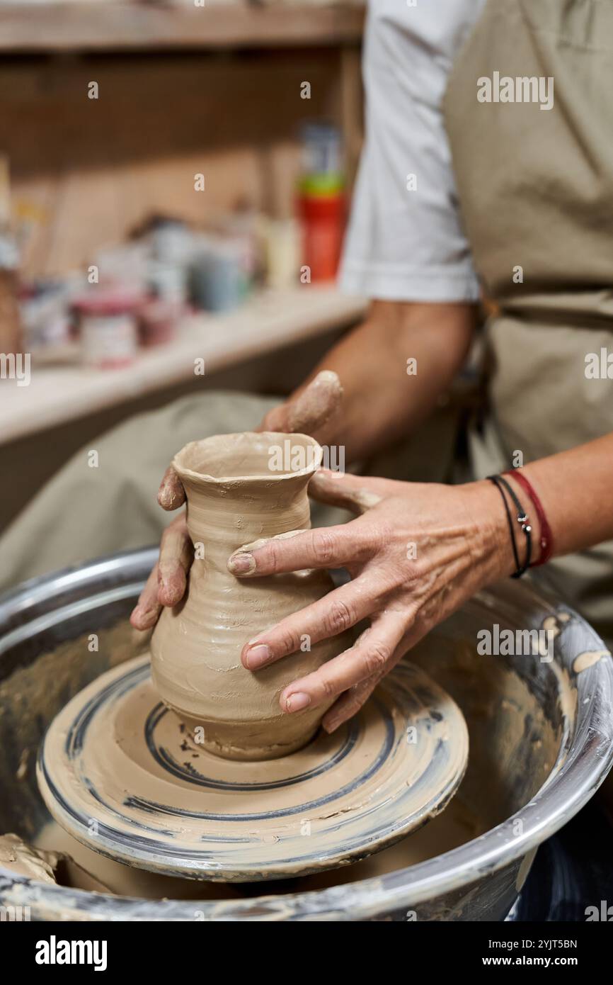 A talented woman expertly molds wet clay on a potters wheel, showcasing ...