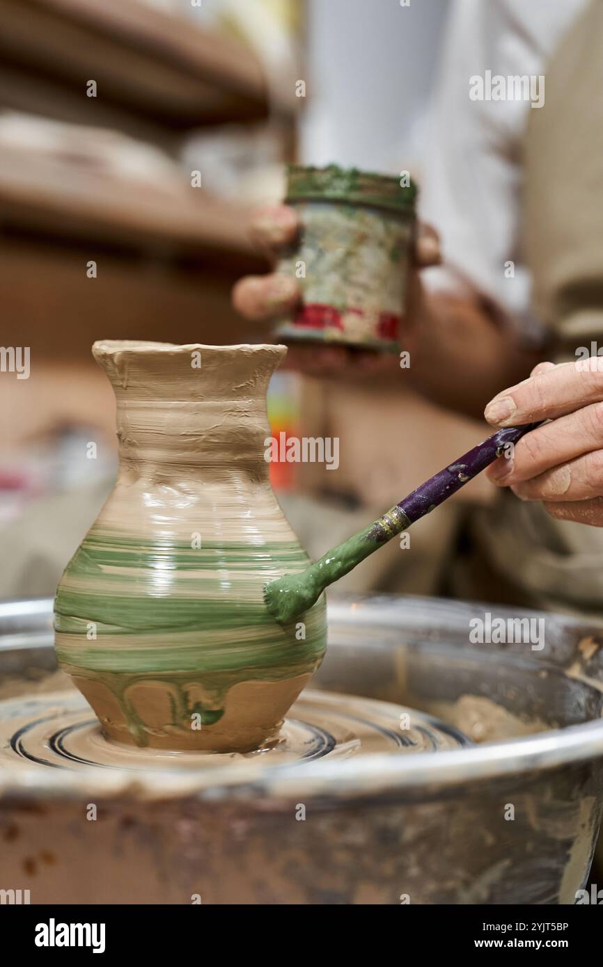 A talented mature artisan works on her pottery, bringing her artistic ...