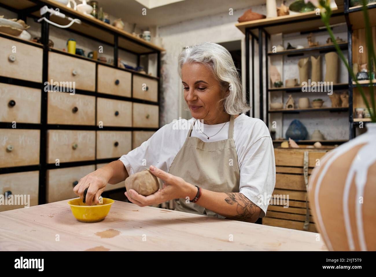 The talented artist molds clay with focused hands, immersed in the joy ...