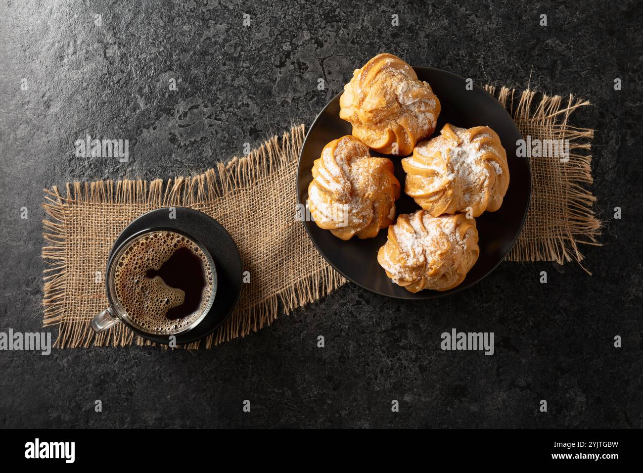 Cream cakes and black coffee on a black stone table. Top view Stock ...