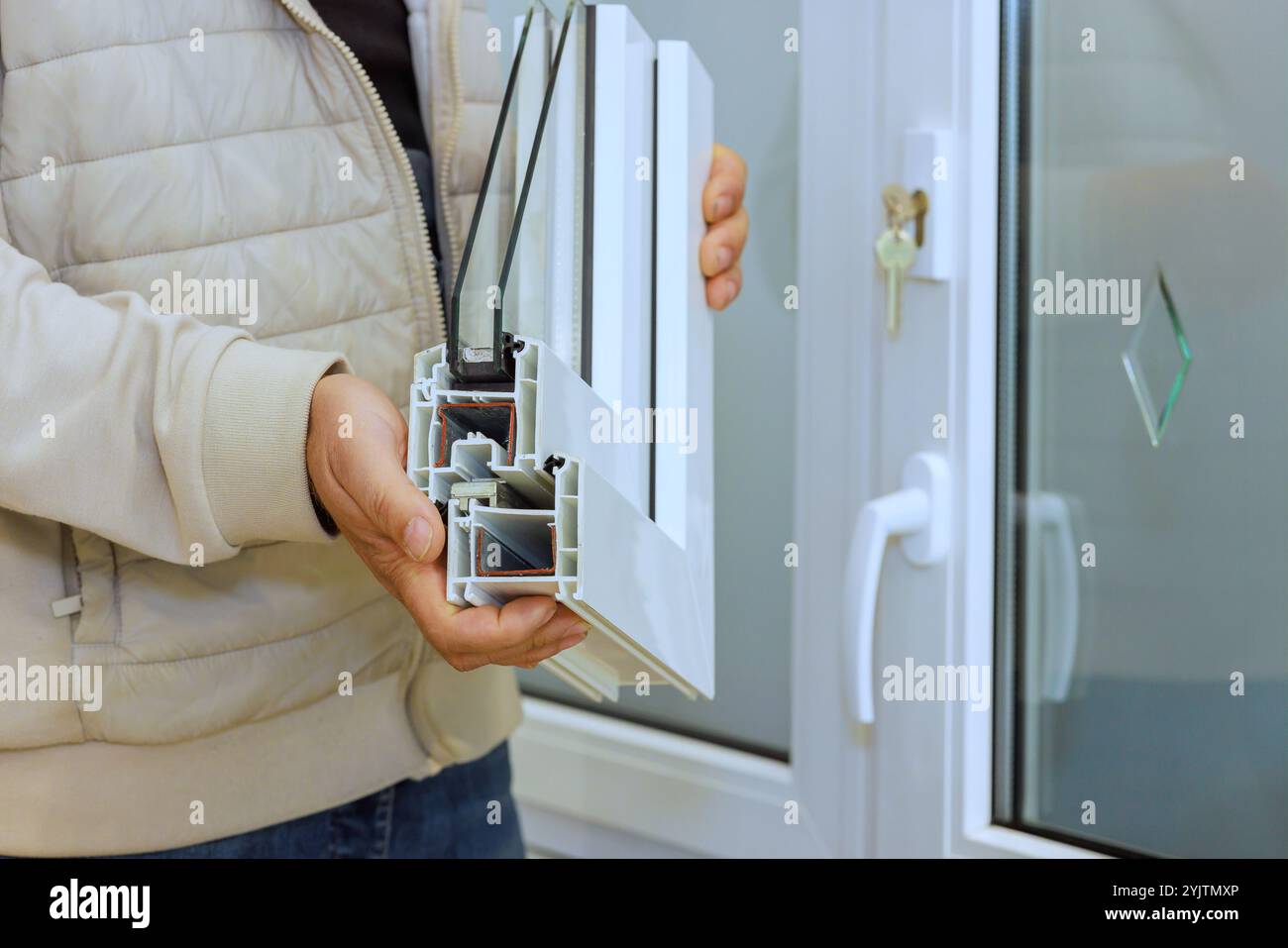 Person examines a cross section of a window frame, showcasing its ...