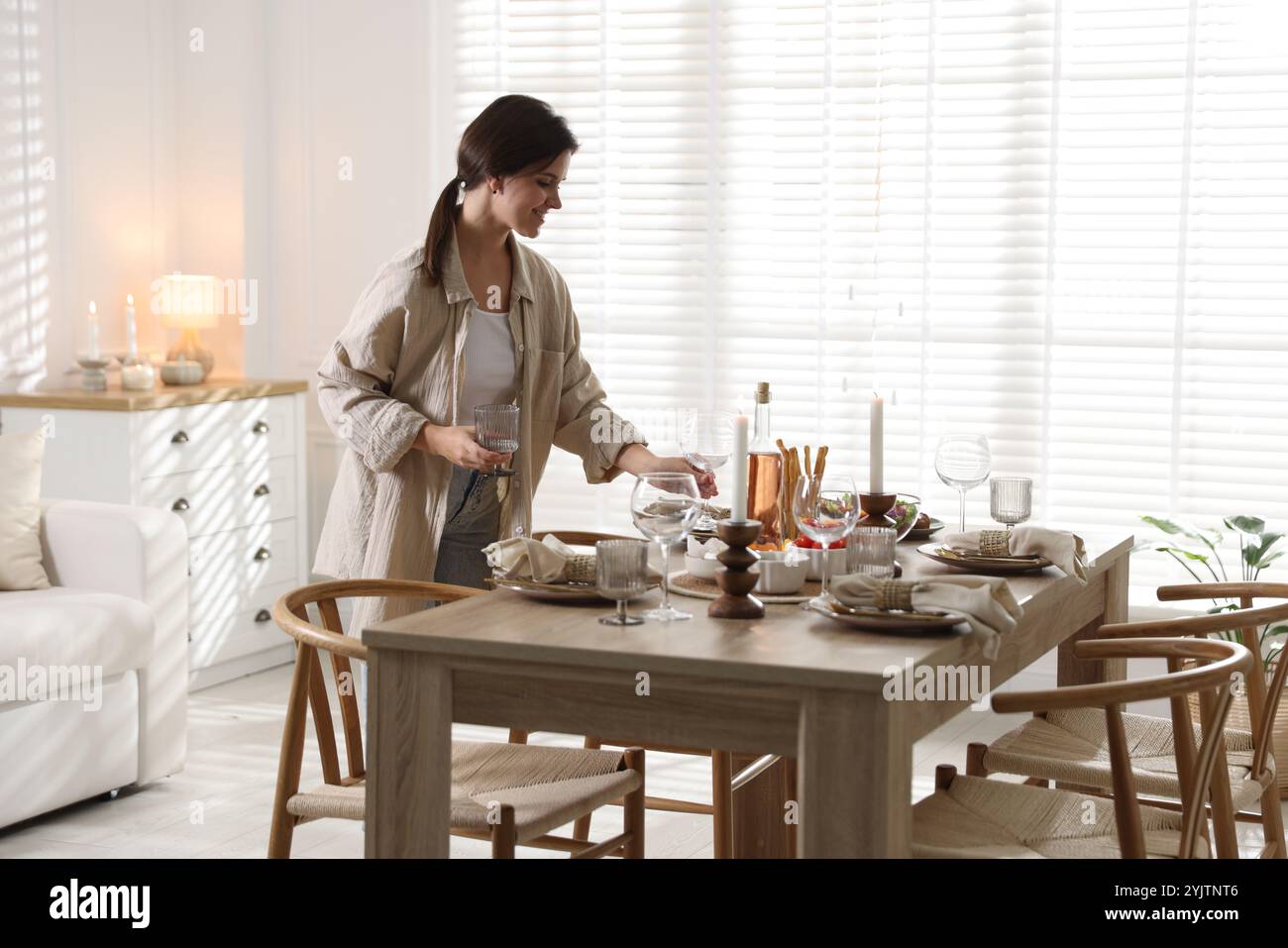 Woman setting table for dinner at home Stock Photo - Alamy