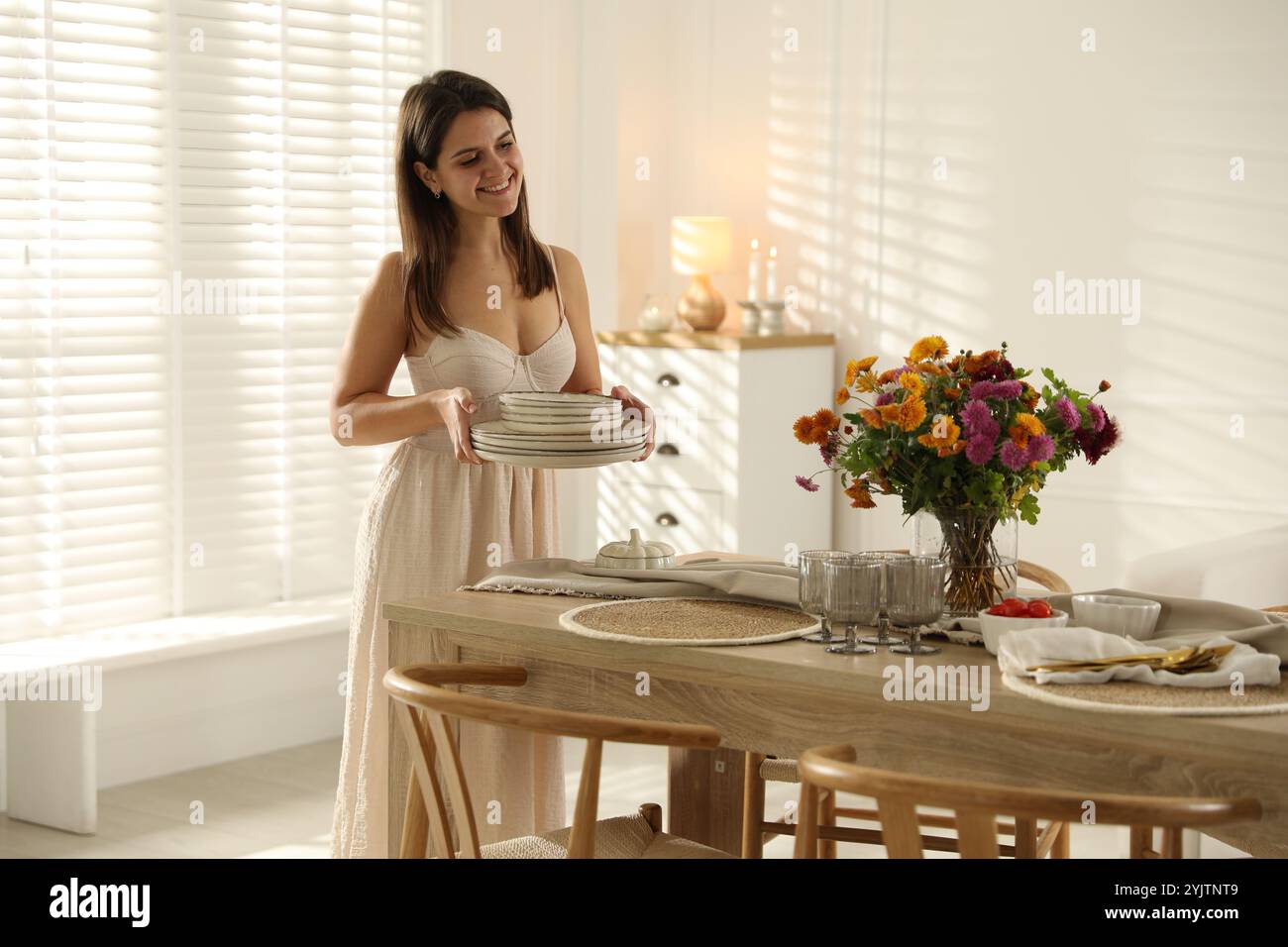 Woman setting table for dinner at home Stock Photo - Alamy