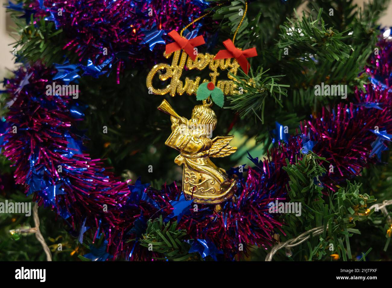 A red Christmas toy in the shape of a flower is hanging on a branch of ...