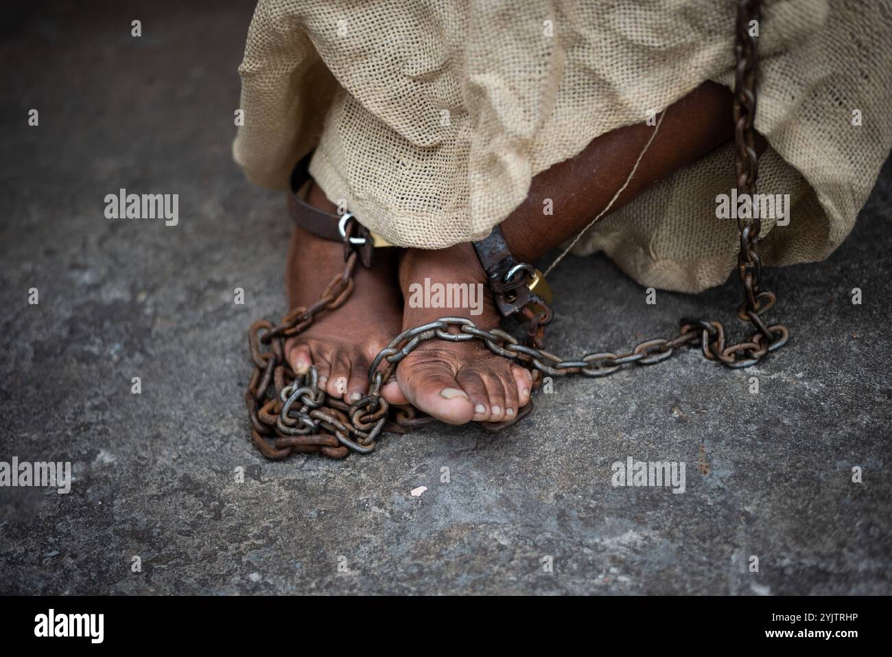 Photo of the chained feet of a black woman sitting on the floor of ...