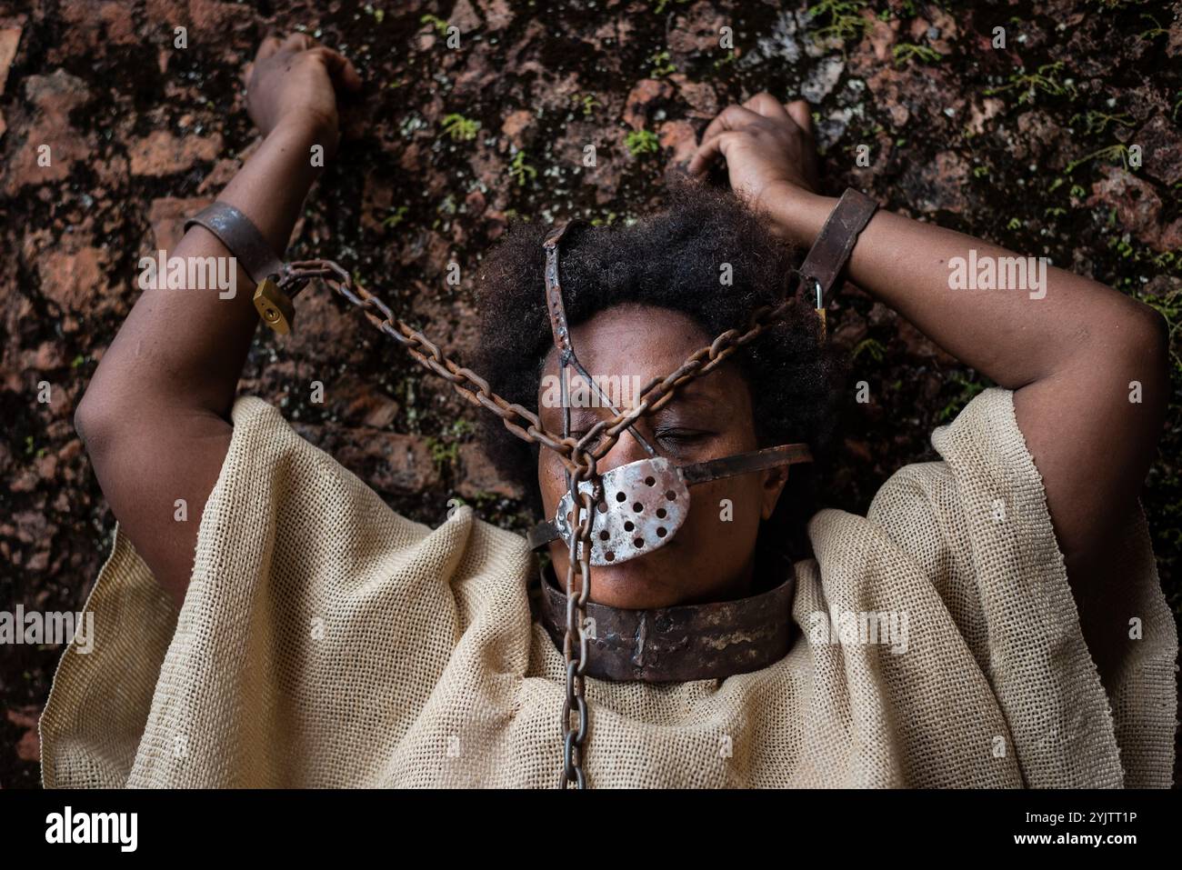 Portrait of a black woman chained with an iron mask on her mouth with ...
