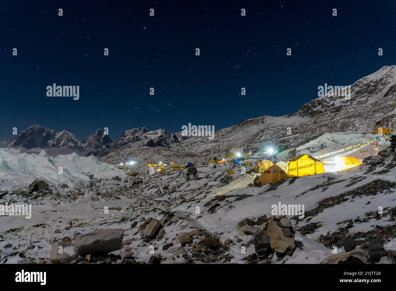 Night time sky over Everest base camp on Khumbu glacier. Tents are lit ...