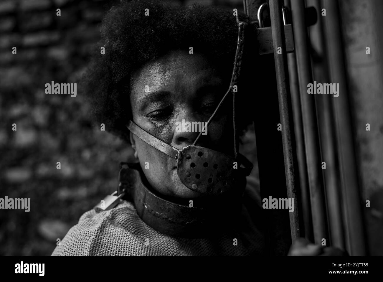 Portrait of a black woman's face with an iron mask stuck in her mouth ...