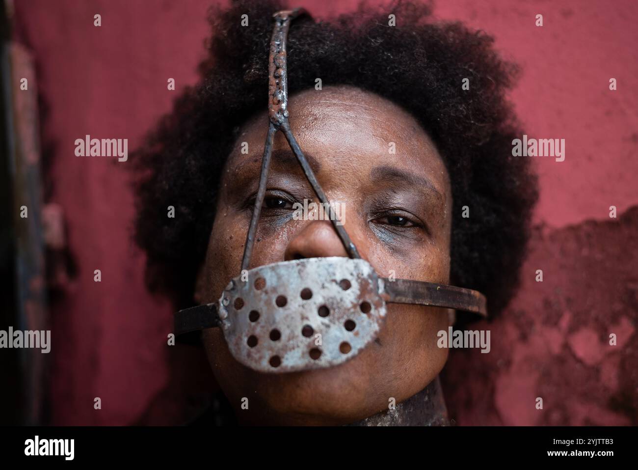 Close-up portrait of a black woman dressed as a slave, chained with an ...