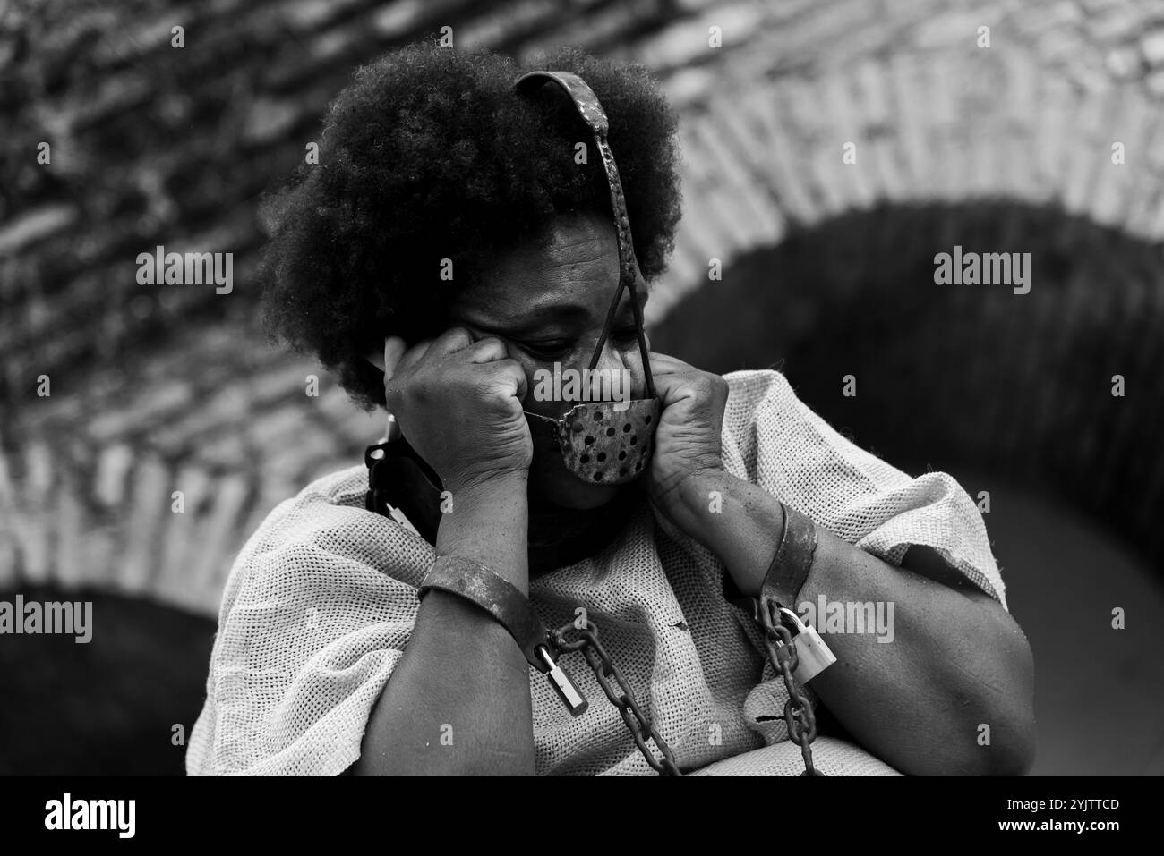 Black woman dressed as a slave, chained and with an iron mask on her ...