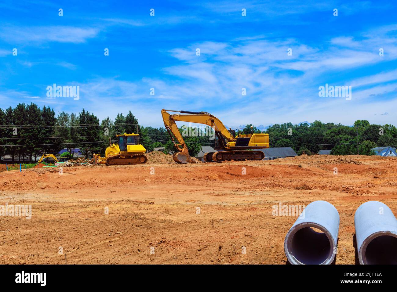 Heavy machinery are actively digging moving earth at construction site ...