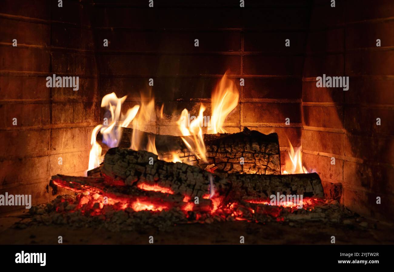 Fire flames, wood logs burning in fireplace. Warm home in winter, heat ...
