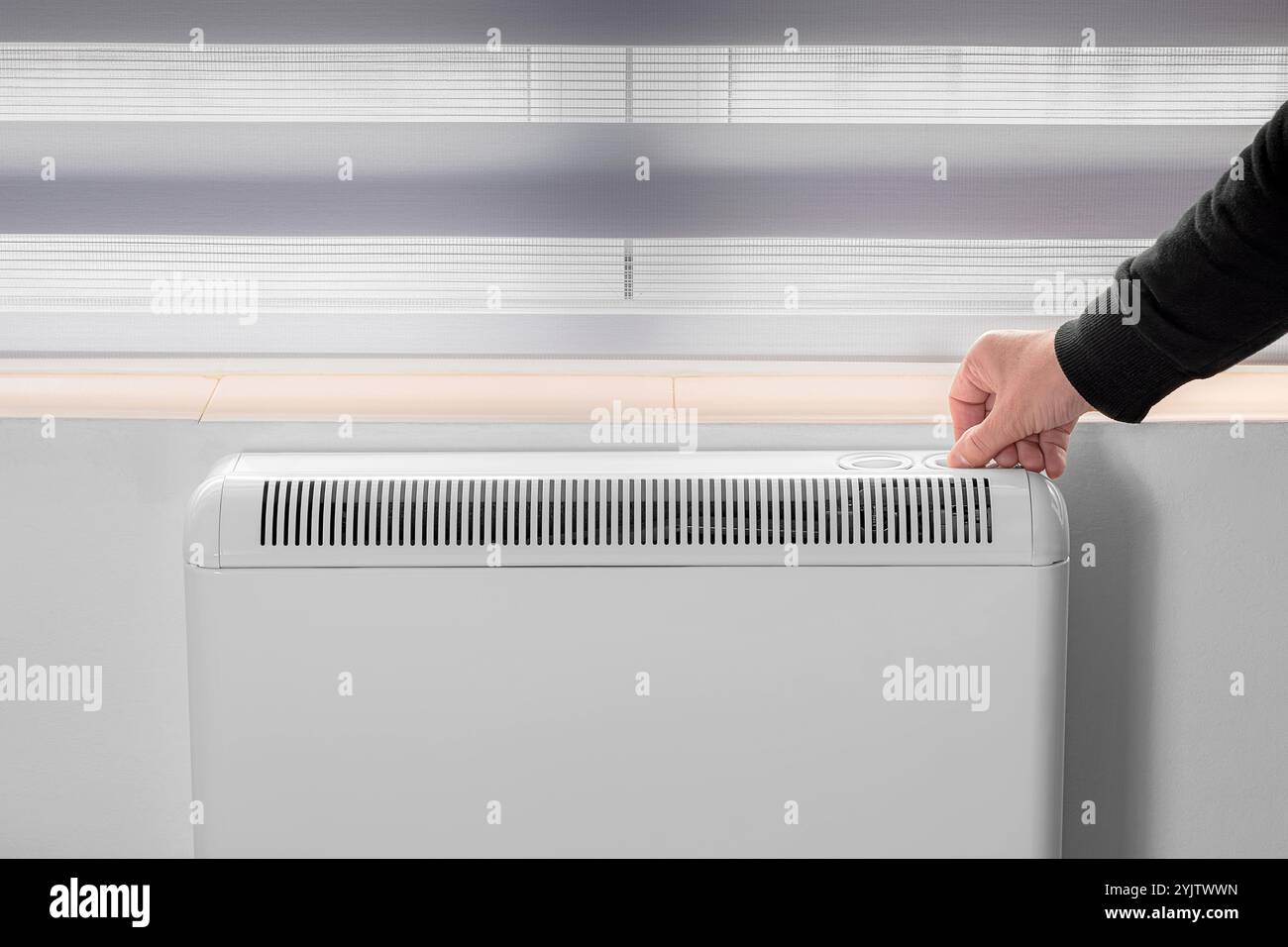 Electric heating. Electric wall radiator placed under a window Stock ...