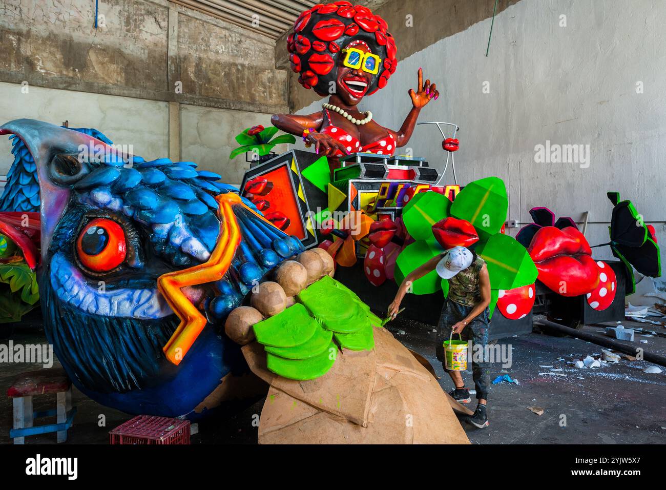 A Colombian artisan paints a paper-mâché sculpture of a bird for an ...