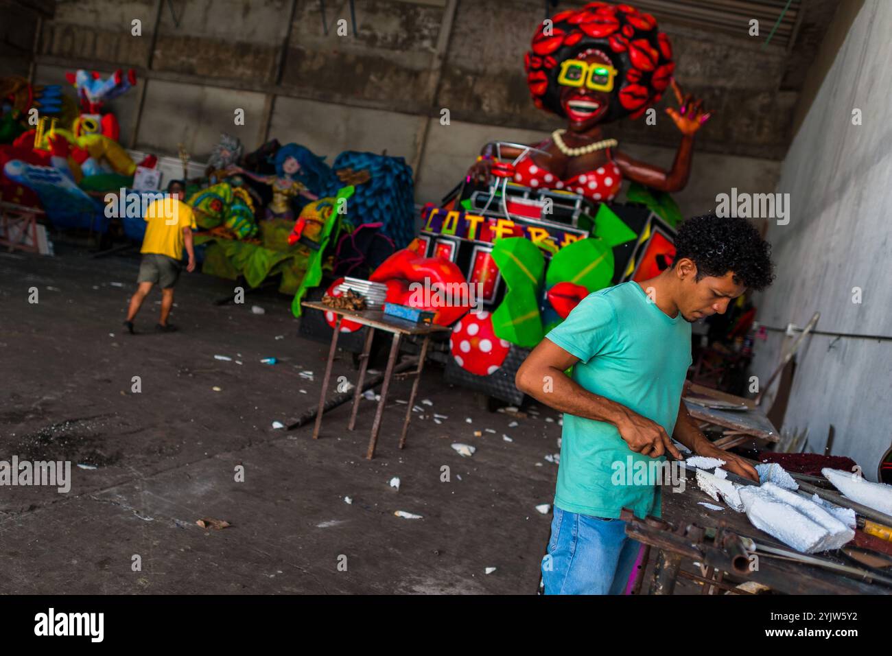A Colombian artisan carves polystyrene shapes for an allegorical float ...