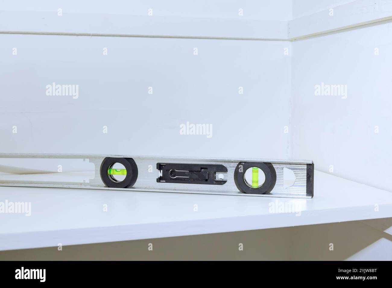 Construction level is placed on newly shelf, aiding in accurately ...