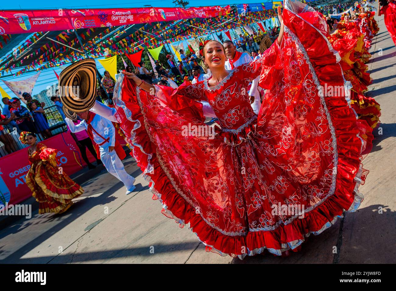 Colombian couples, wearing traditional cumbia outfits, dance the cumbia ...