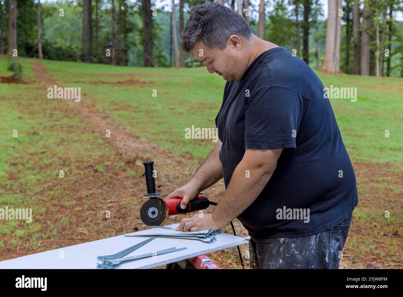 Craftsman is focused on using an angle grinder to cut through piece of ...