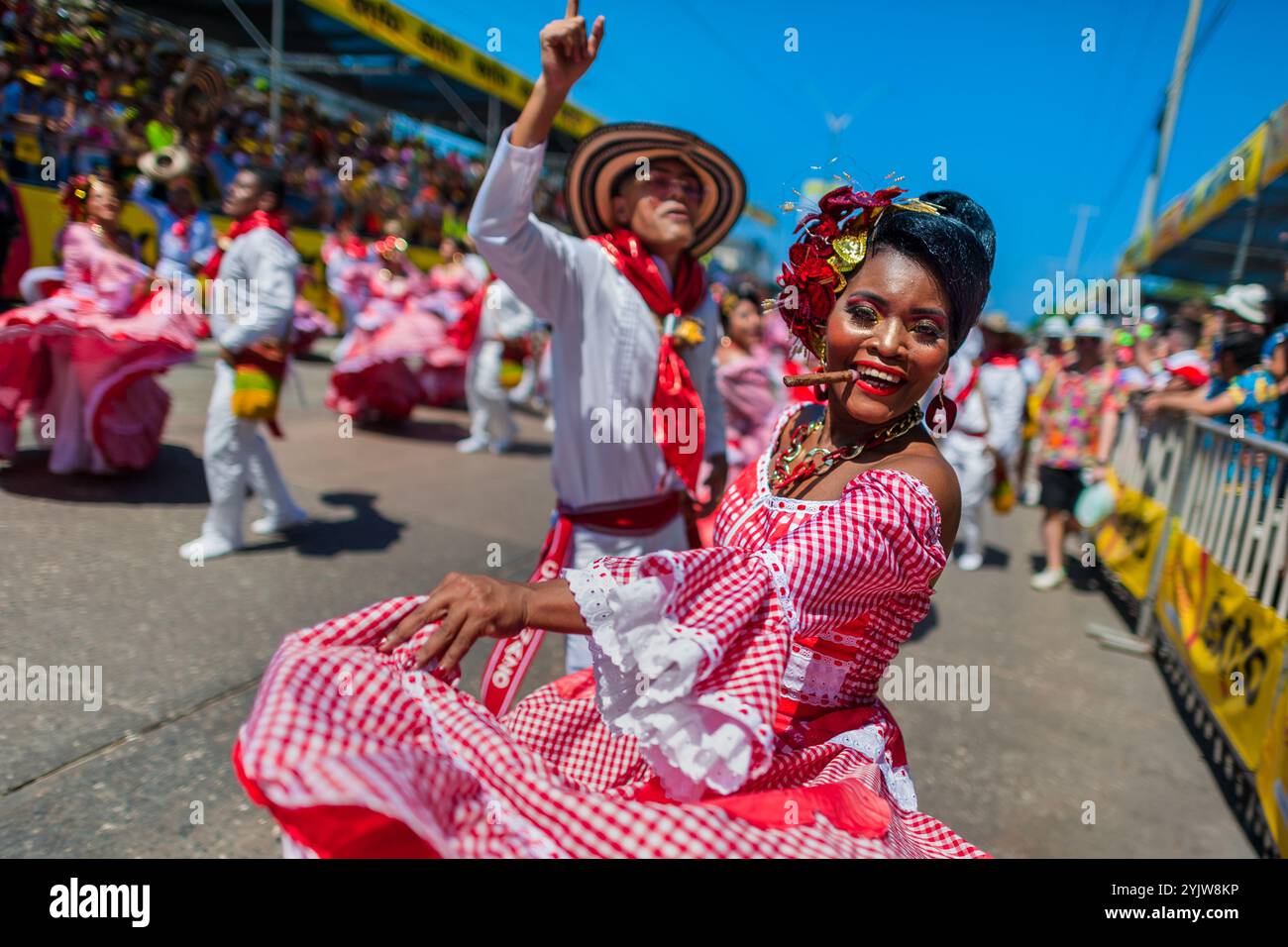 Afro-Colombian couples, wearing traditional cumbia outfits, dance the ...
