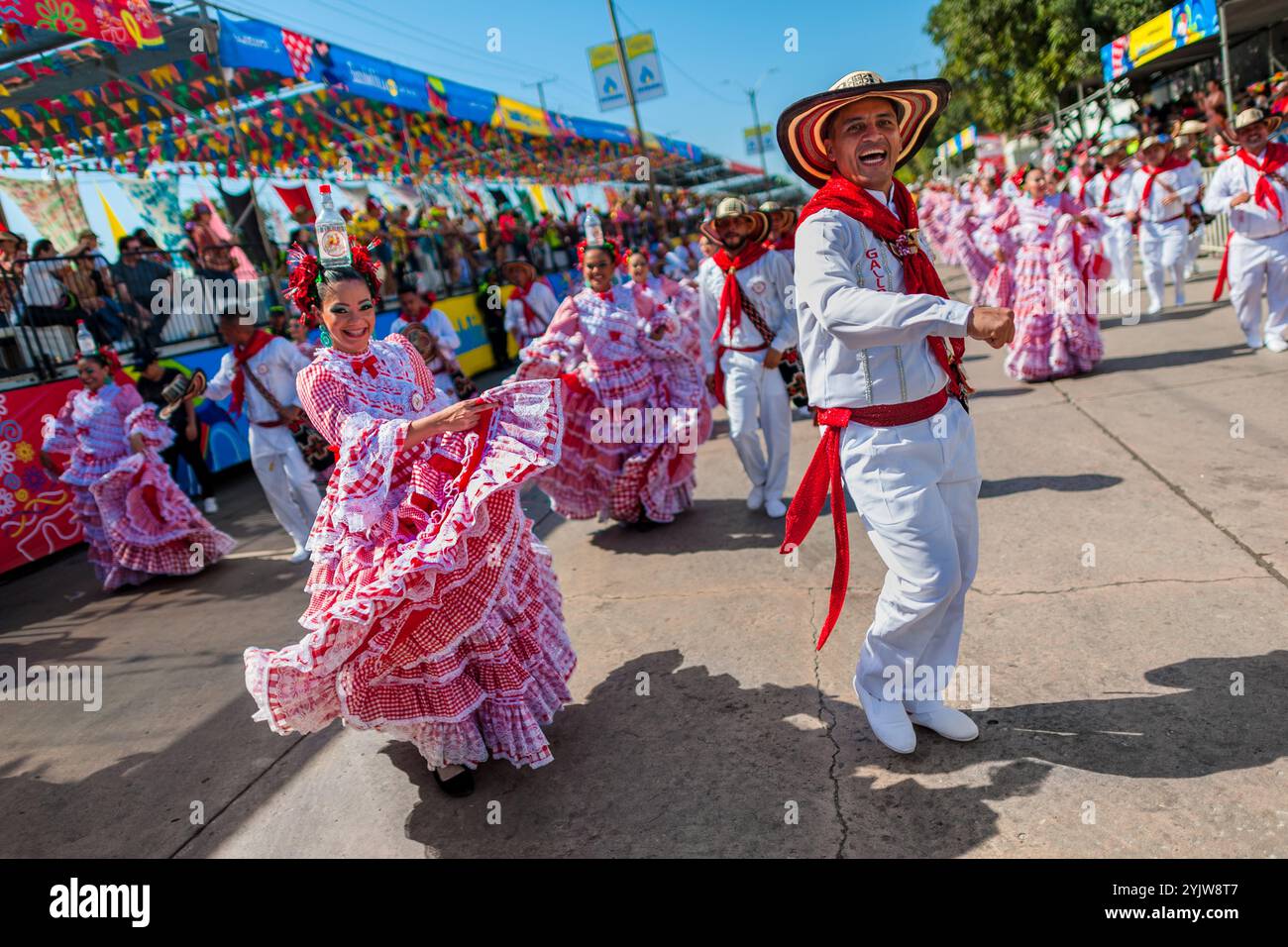 Colombian couples, wearing traditional cumbia outfits, dance the cumbia ...