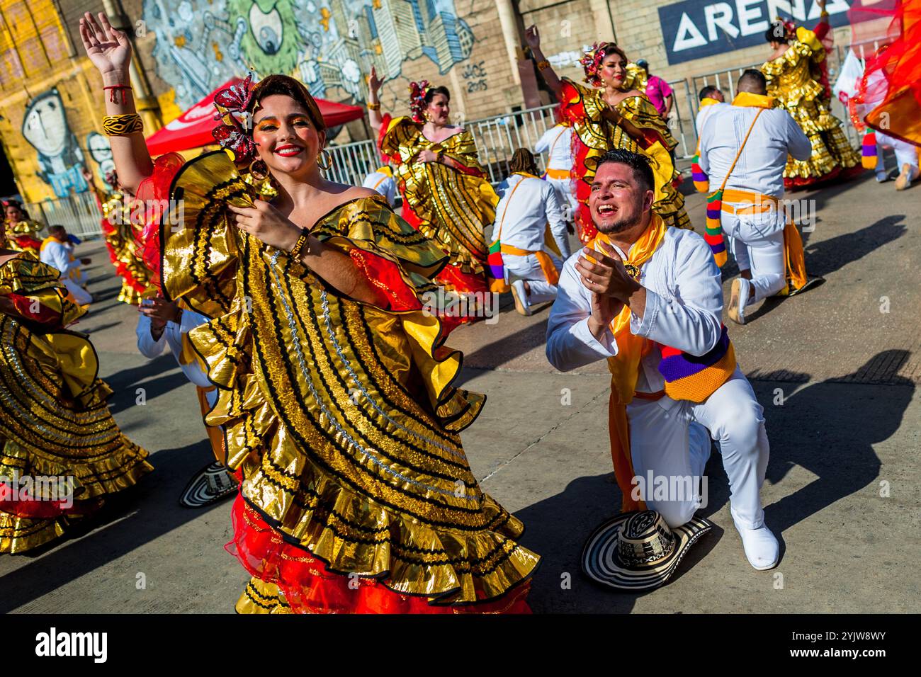 Colombian couples, wearing traditional cumbia outfits, dance the cumbia ...