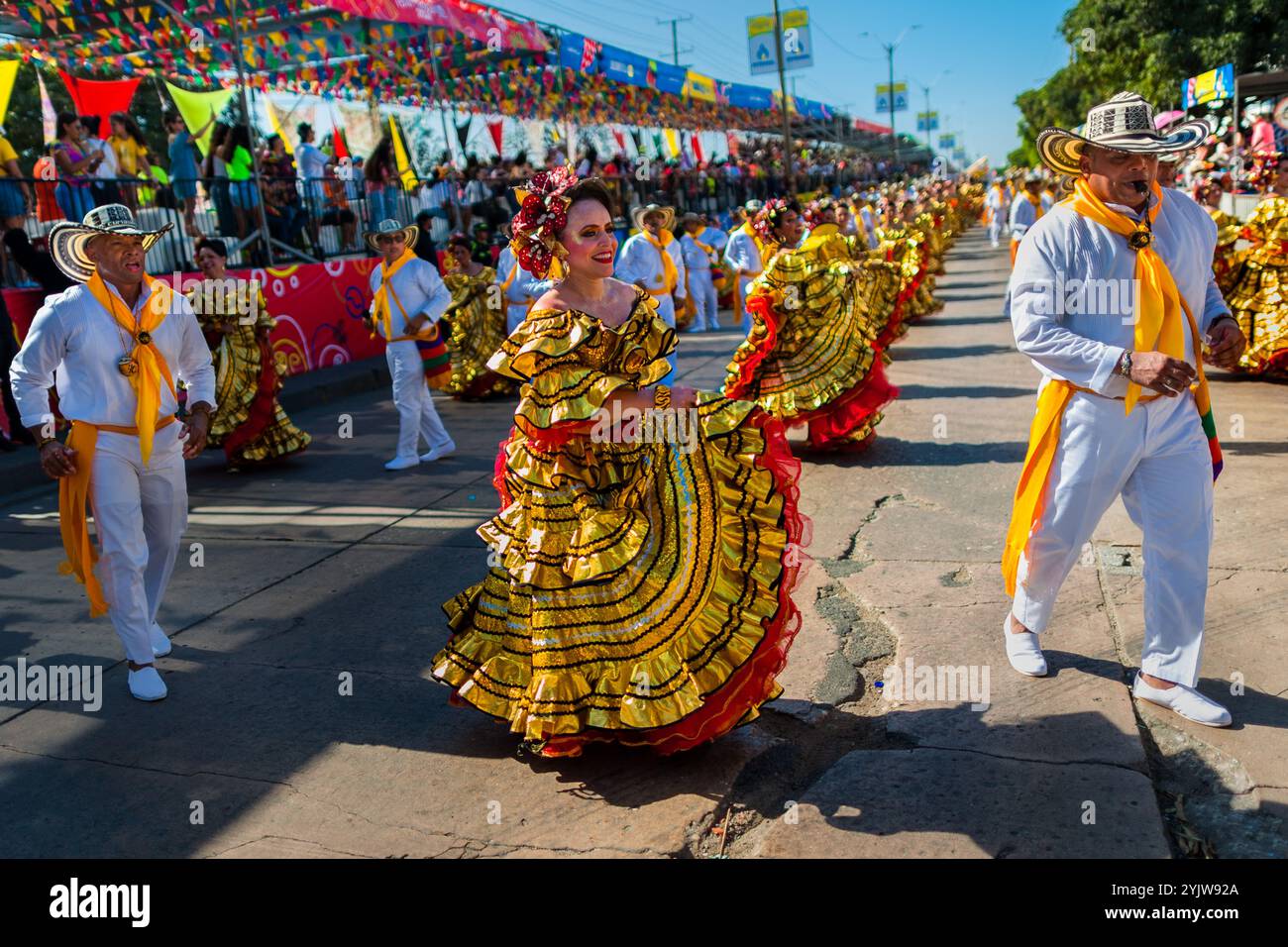 Colombian couples, wearing traditional cumbia outfits, dance the cumbia ...