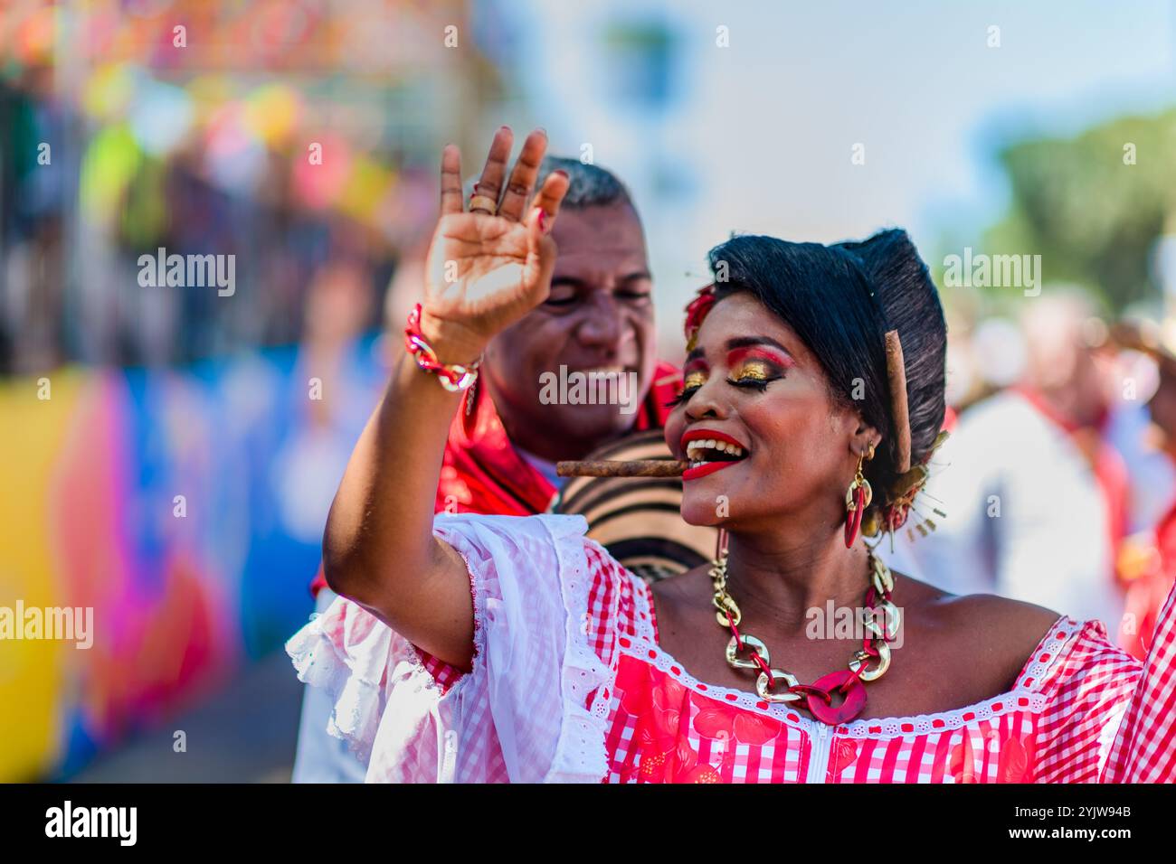 An Afro-Colombian couple, wearing traditional cumbia outfits, dances ...