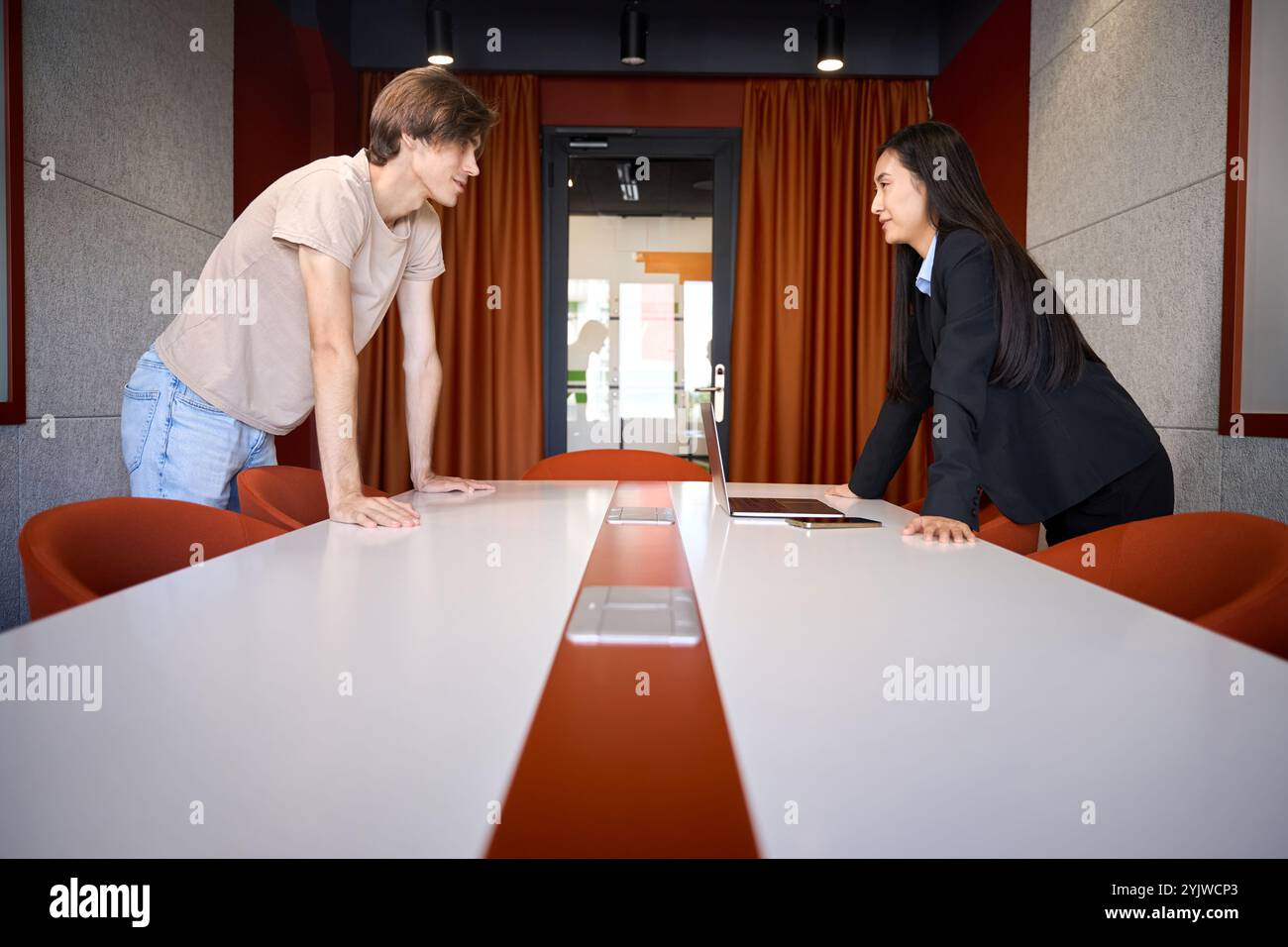 Woman in a business suit stands opposite a young man Stock Photo - Alamy
