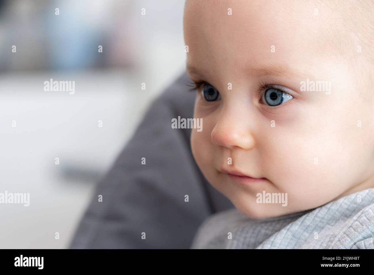 Thoughtful baby with blue eyes in soft focus. Concept of innocence and ...