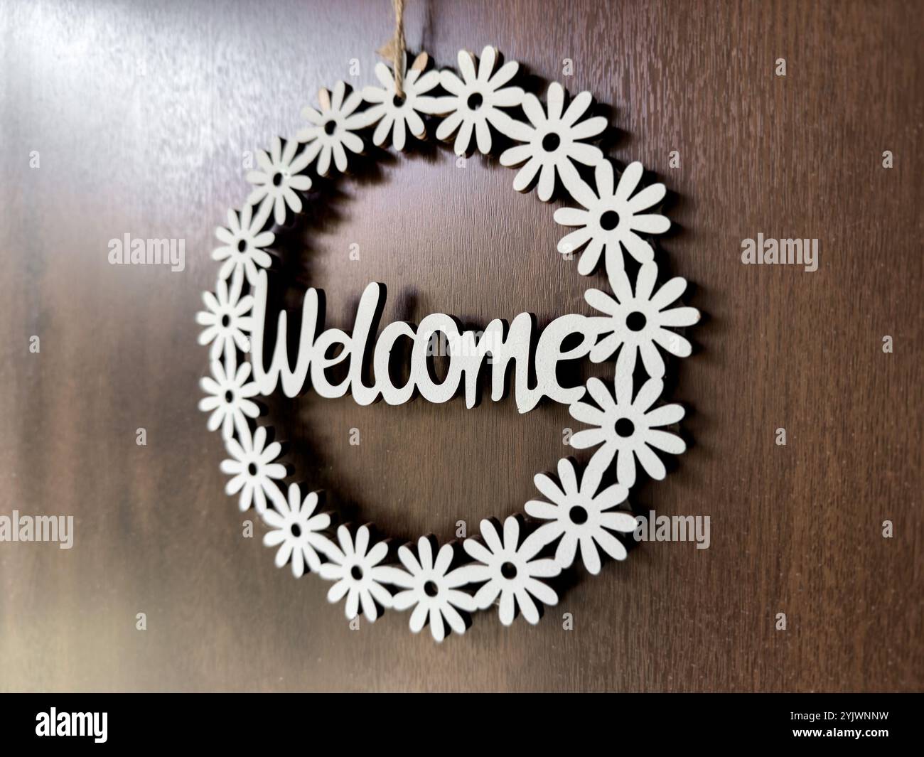 White Welcome sign hanging on door welcoming guests, focused on text ...