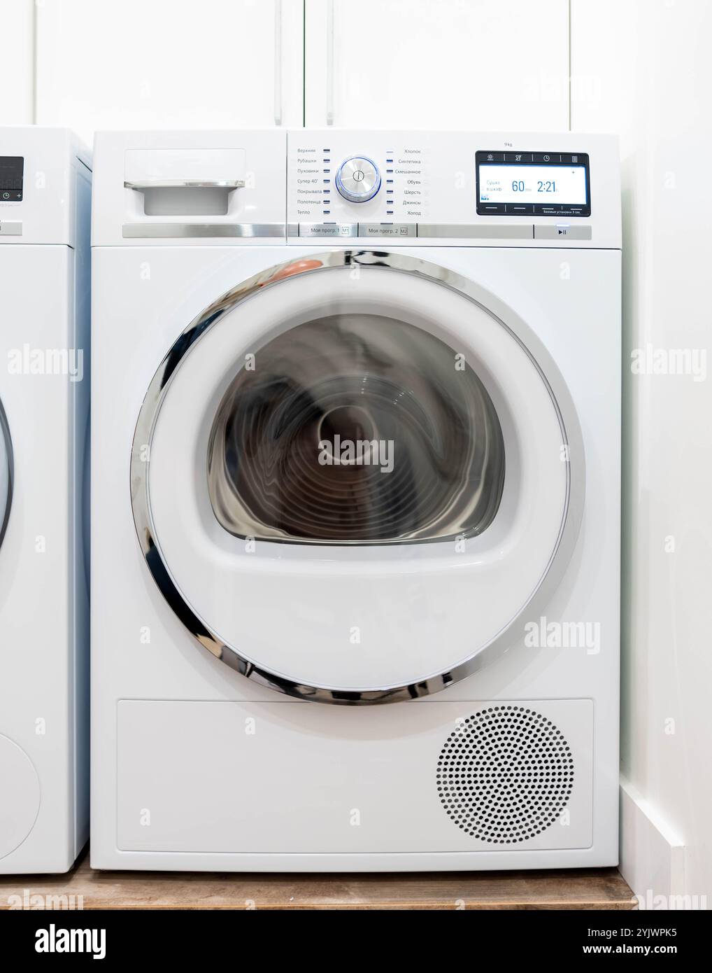 A high-efficiency front-loading dryer machine in a sleek laundry room ...