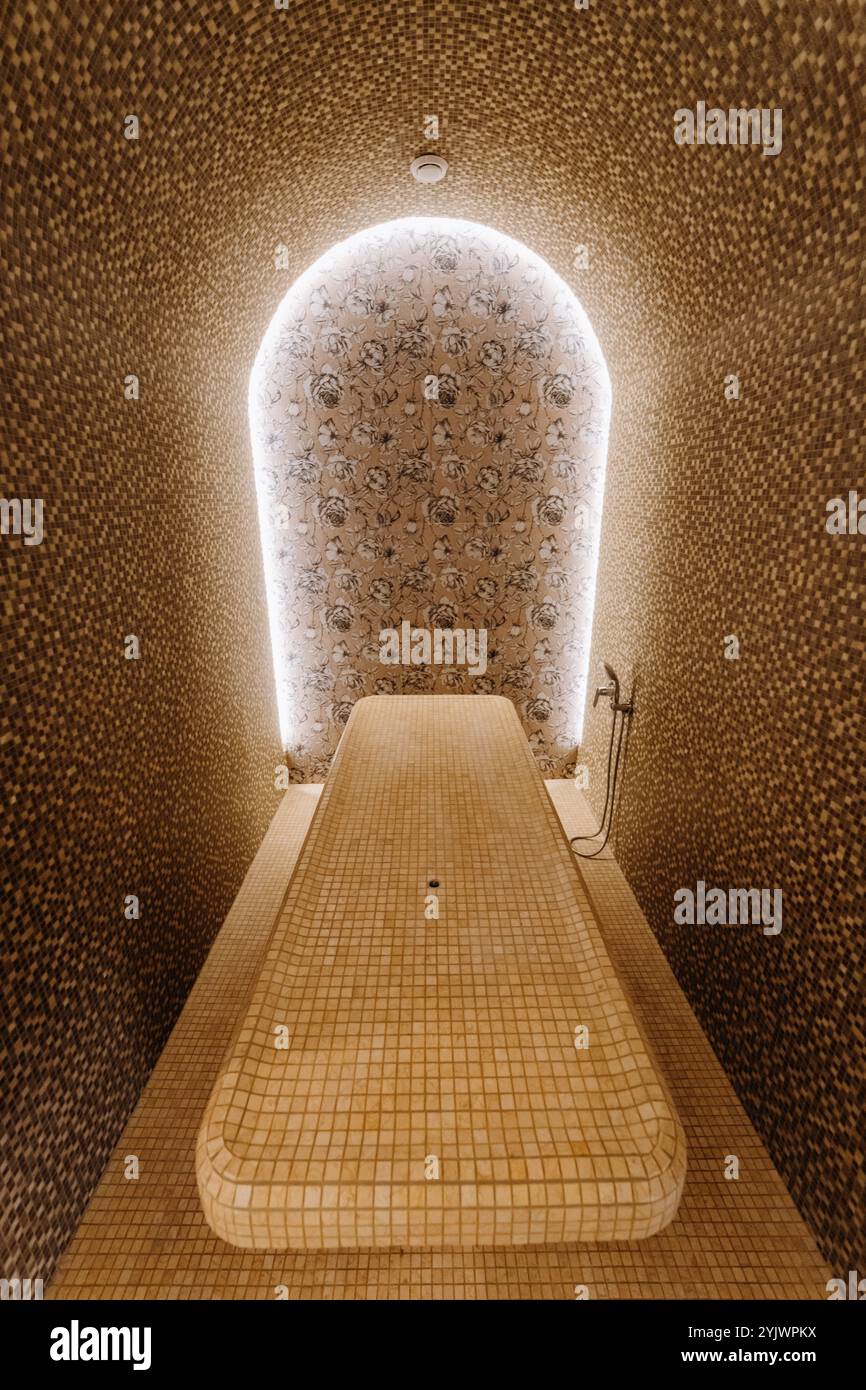 Luxurious spa steam room with tiled massage table and ambient lighting for ultimate relaxation ...