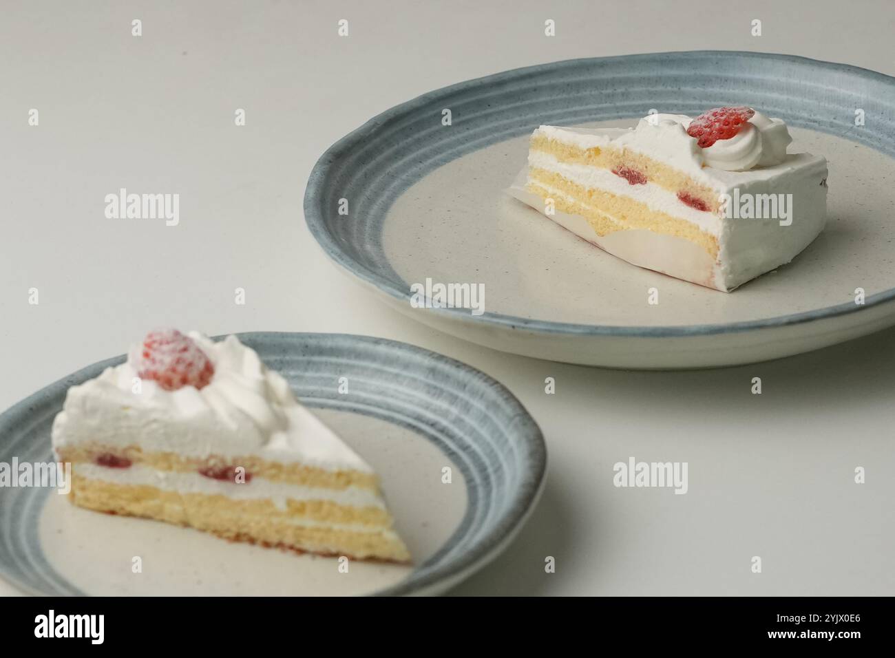 Two Japanese strawberry shortcakes, one on a stylish small plate and ...