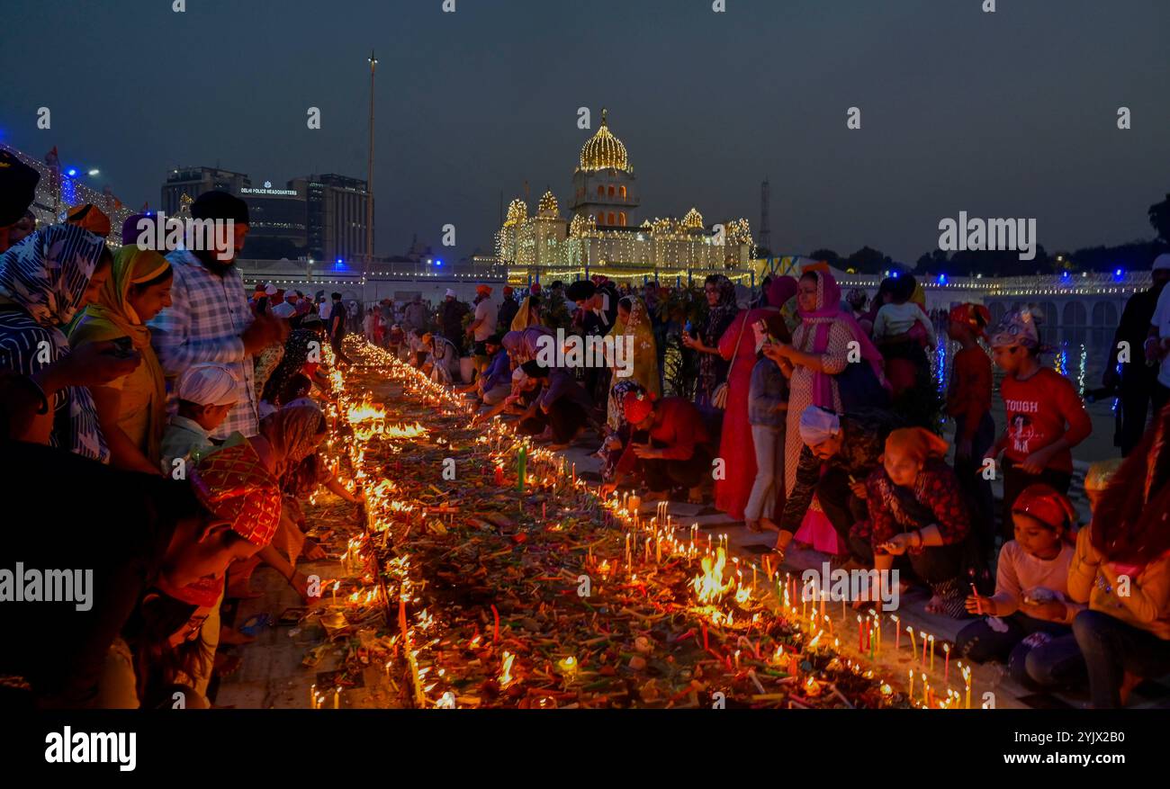 NEW DELHI, INDIA - NOVEMBER 15: Devotees seen lighting the candles on the occasion of 555th Guru ...
