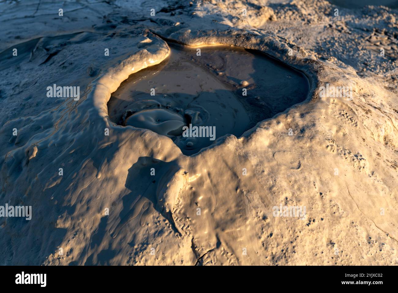 Close-up of a bubbling mud pool in a volcanic area, capturing the ...