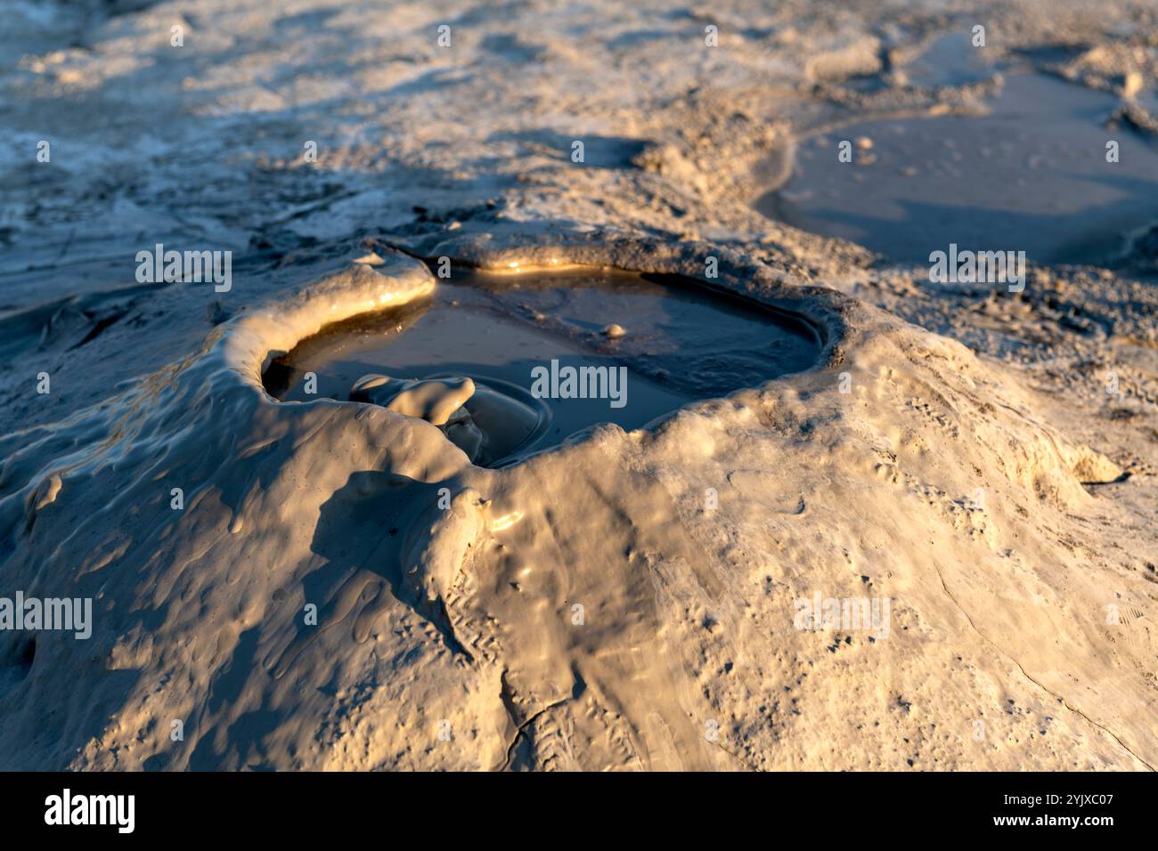 Close-up of a bubbling mud pool in a volcanic area, capturing the ...
