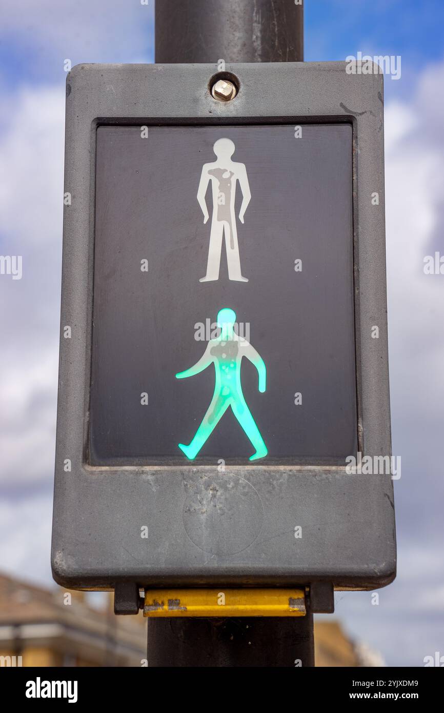 Green luminous pedestrian crossing sign at pedestrian crossing, London ...