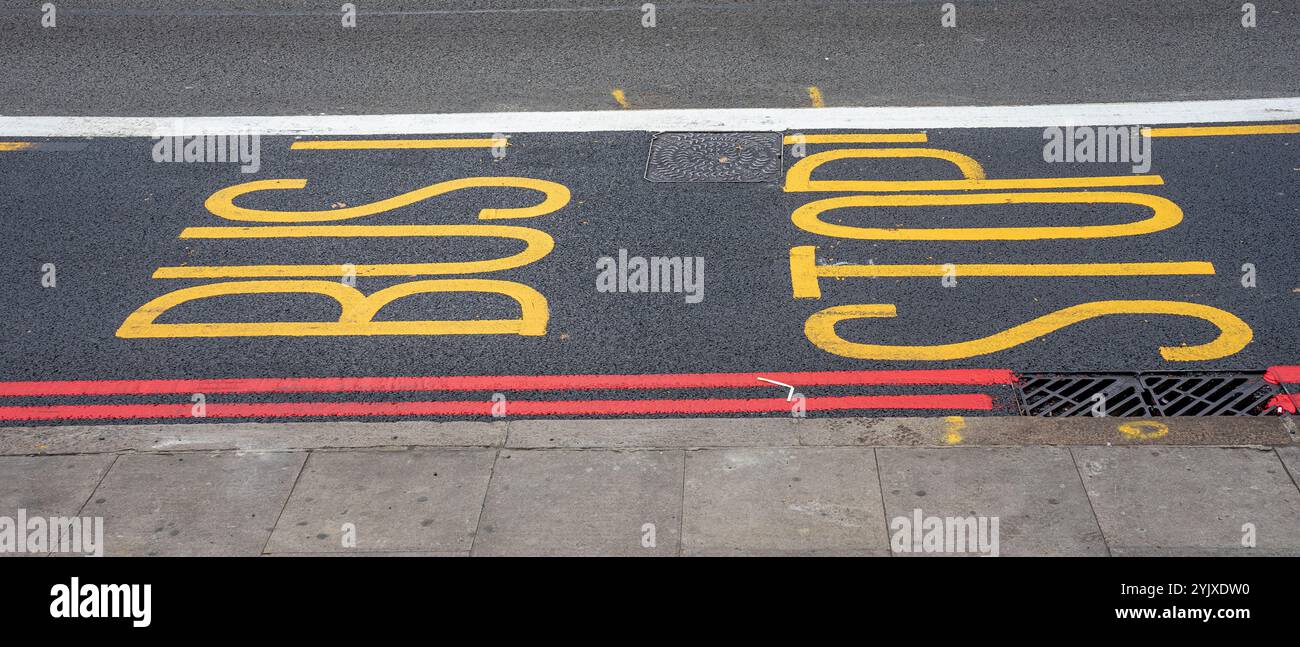 front part of bus arriving at the stop, written on the ground in yellow ...