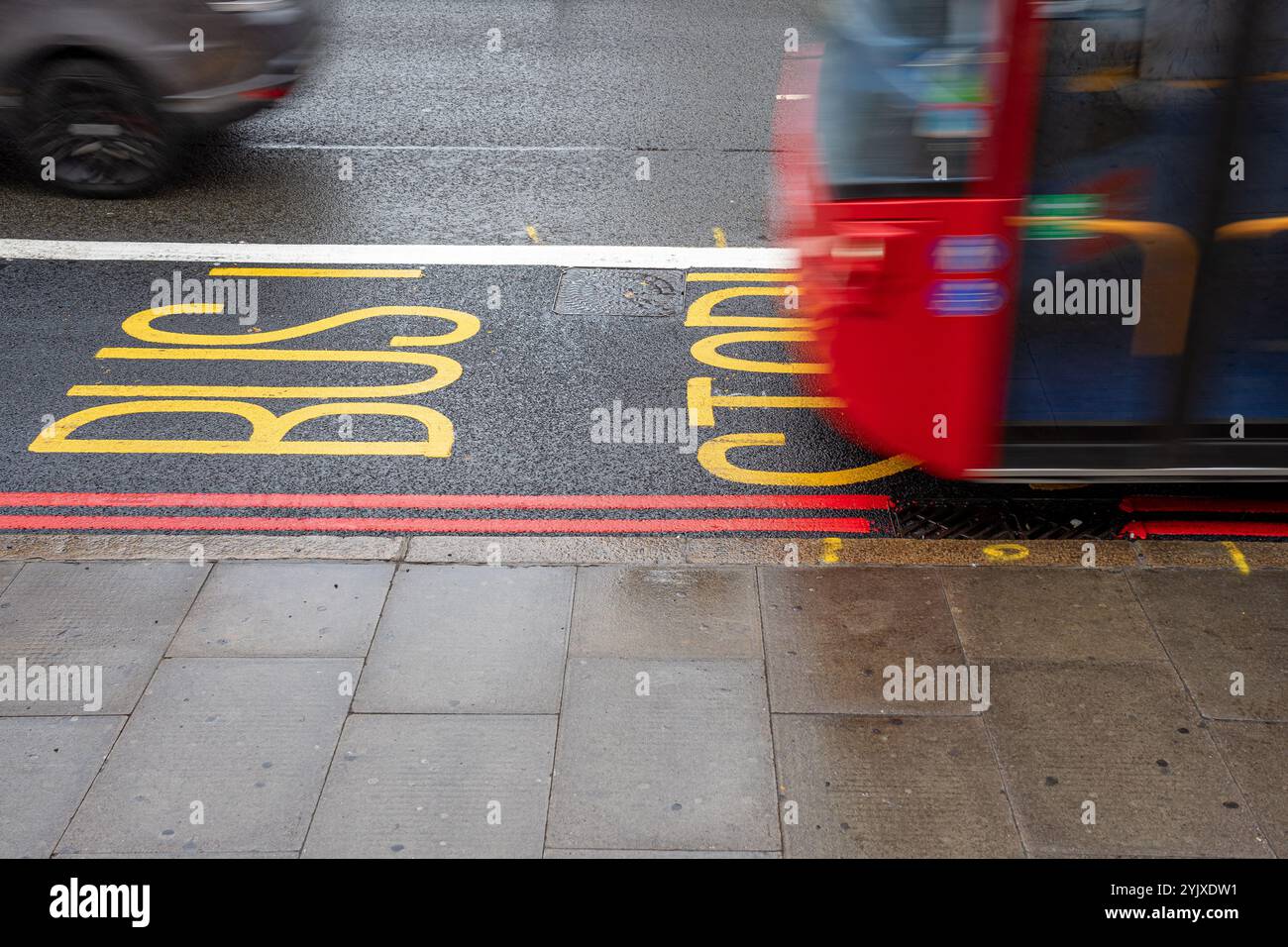 front part of bus arriving at the stop, written on the ground in yellow ...